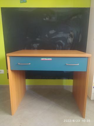 scrivania color legno con cassettone blu.