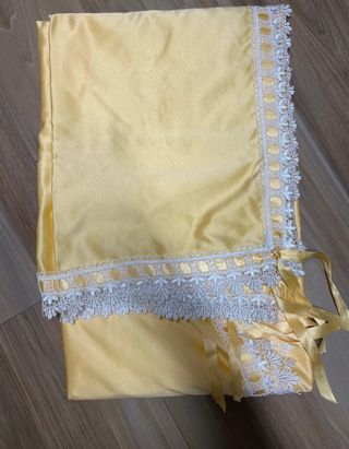 Tovaglia di colore oro con ricami e fiocchetti