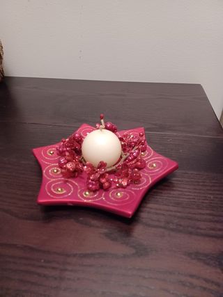 Candela natalizia con piattino rosso decorato.