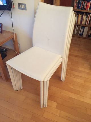 Quattro sedie in ecopelle bianca e una cassettiera