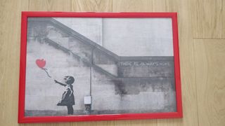 Cornice rossa e poster Banksy