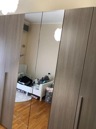 Armadio moderno a 6 ante, con specchio centrale.
