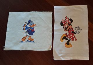 Due ricami a mano a punto croce su tela grezza.