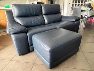 Divano a tre posti blu con pouf