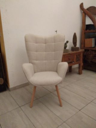 Poltroncina beige rivestita in soffa.
