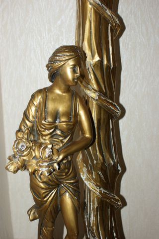 Piedistallo color oro di donna con i fiori